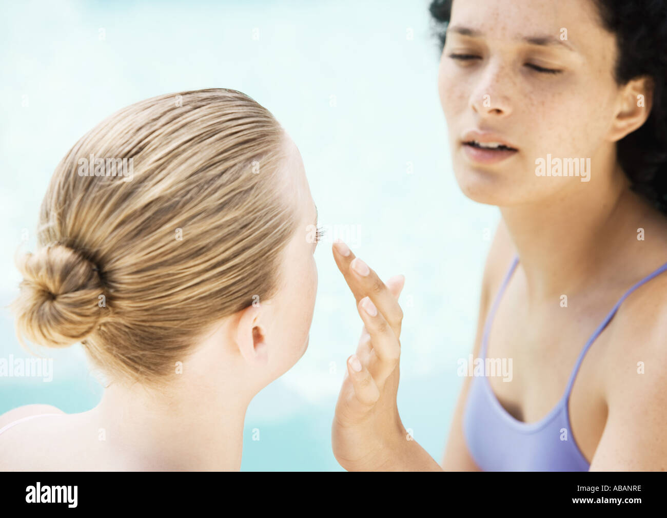 Woman applying sunscreen to friend's face Stock Photo - Alamy