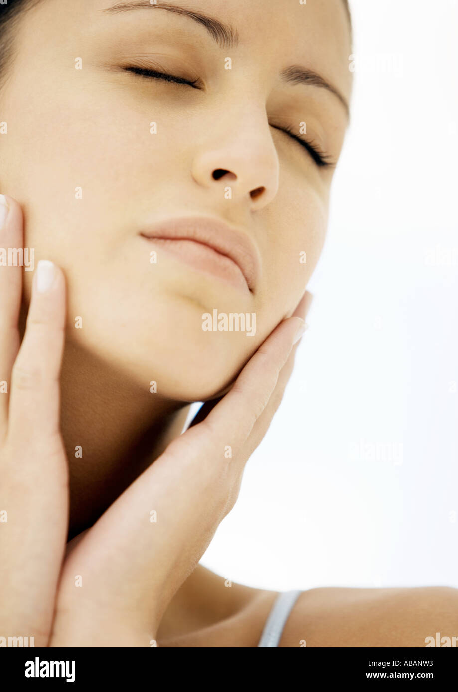 Woman touching face with eyes closed Stock Photo - Alamy