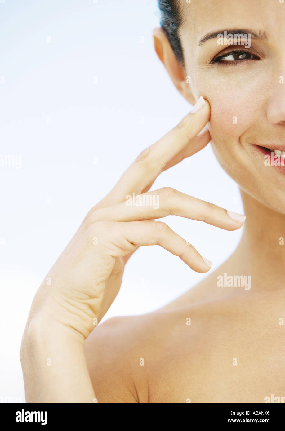 Woman touching cheek and smiling Stock Photo - Alamy