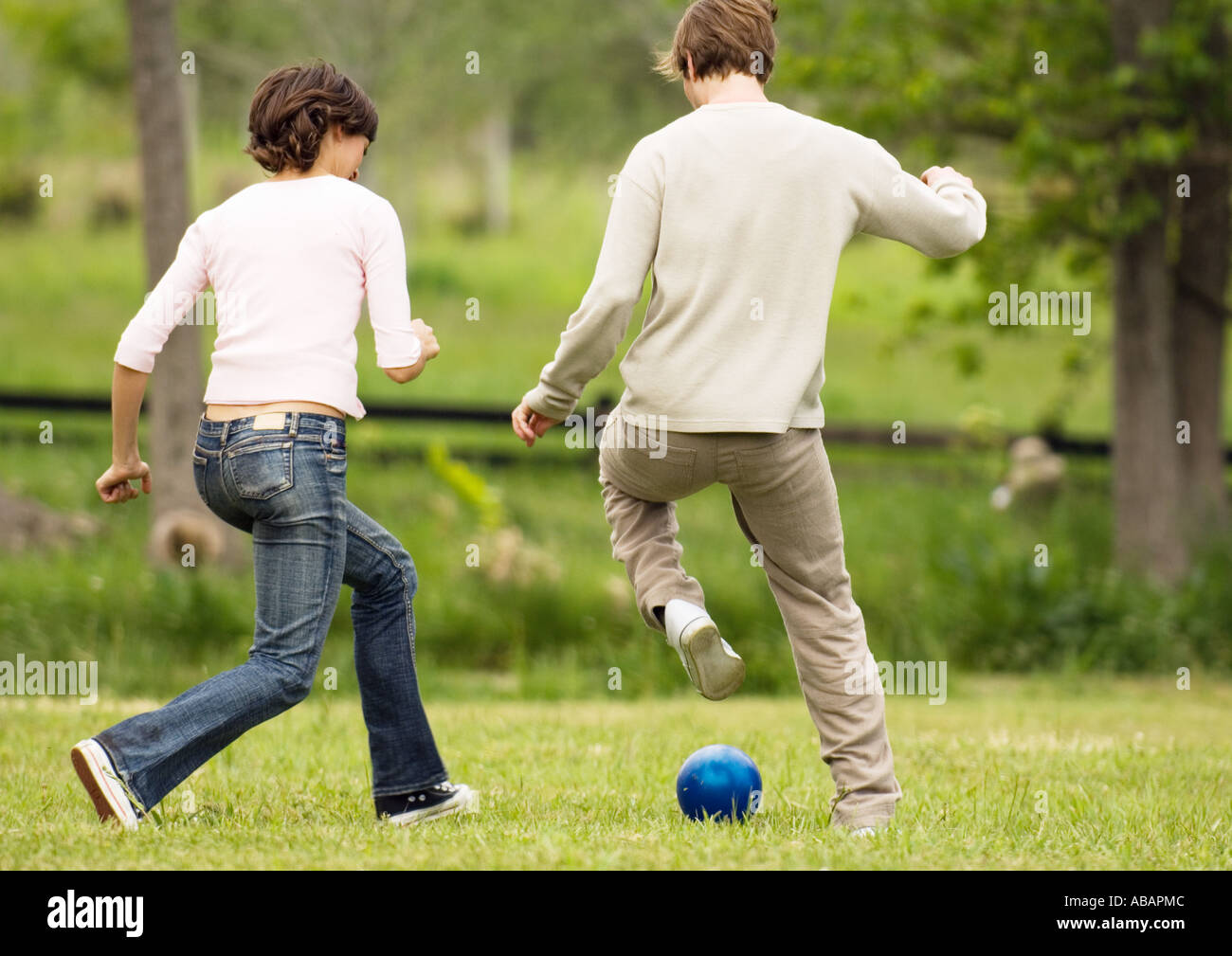 Two friends running after ball Stock Photo - Alamy