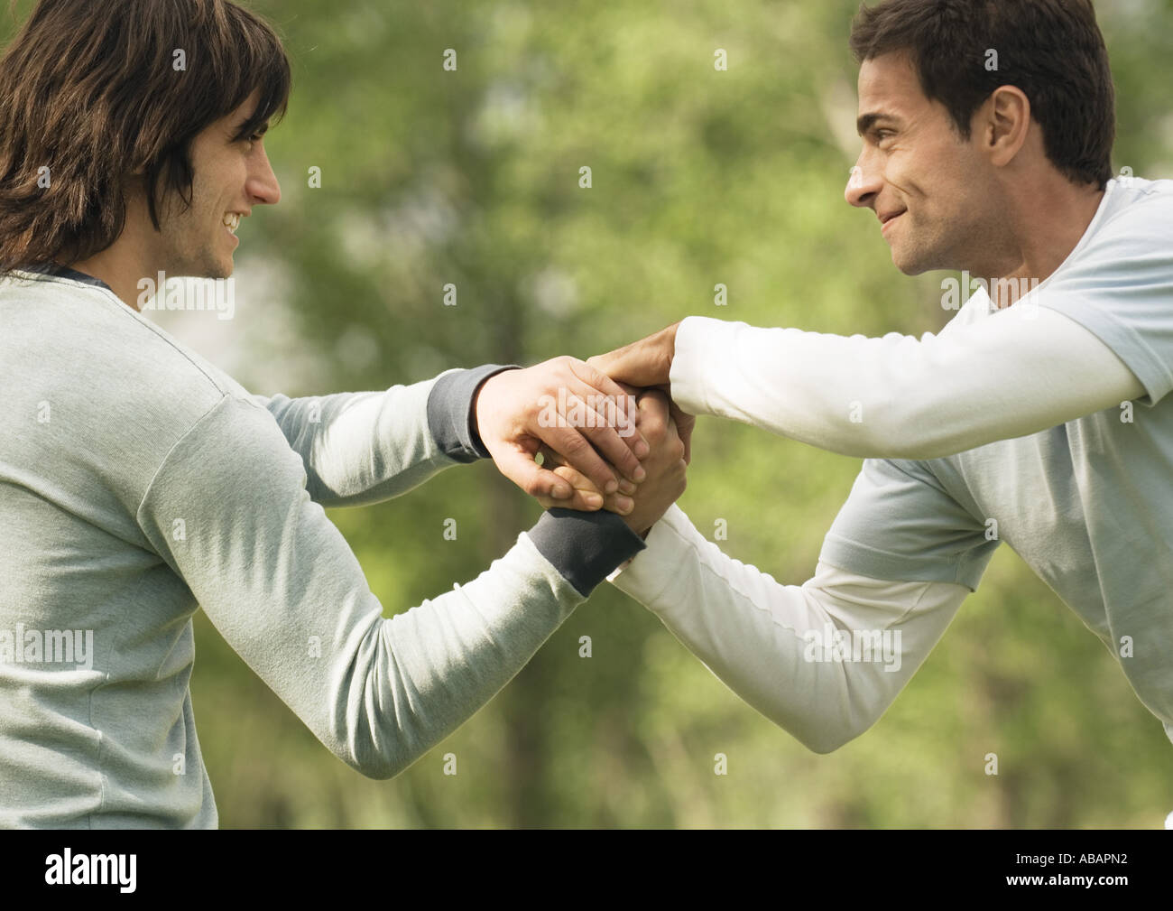Two young male friends with hands clasped Stock Photo - Alamy