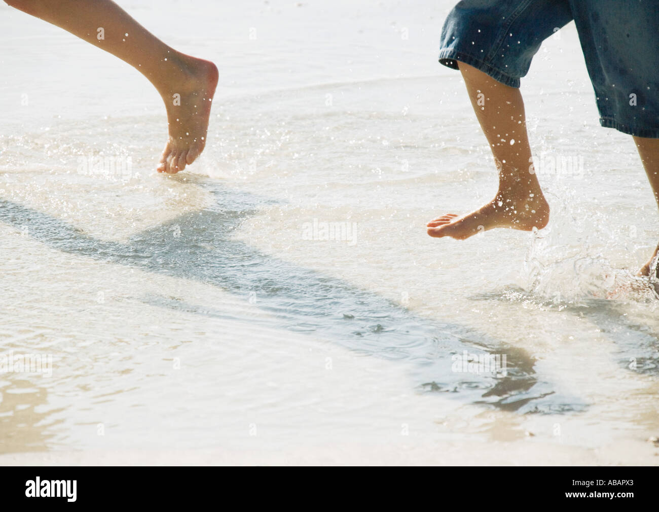 Feet running through surf Stock Photo - Alamy