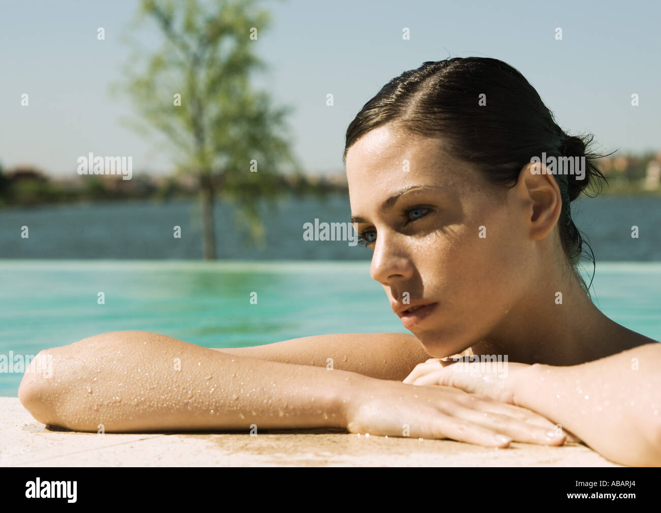 Woman leaning on edge of pool Stock Photo - Alamy