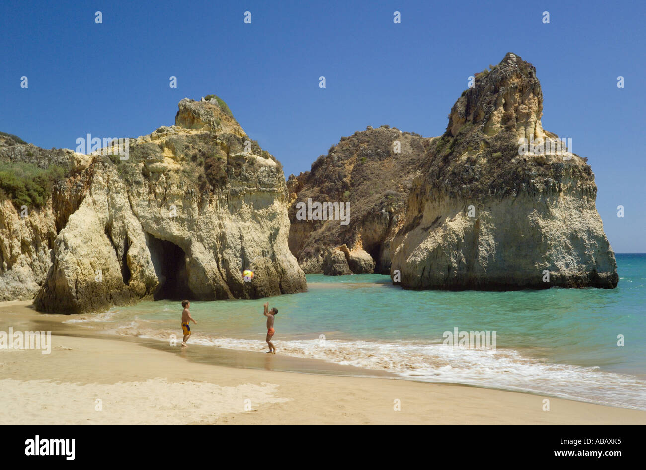 2 children on Alvor Beach and Cliffs Stock Photo - Alamy