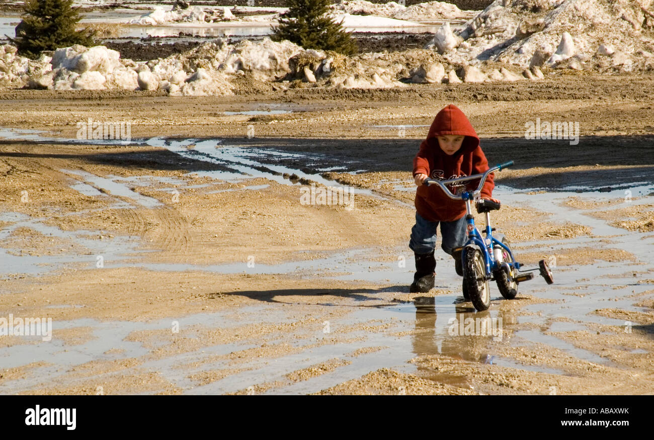 Five-year-old can t peddle his bicycle through the mud and must push ...