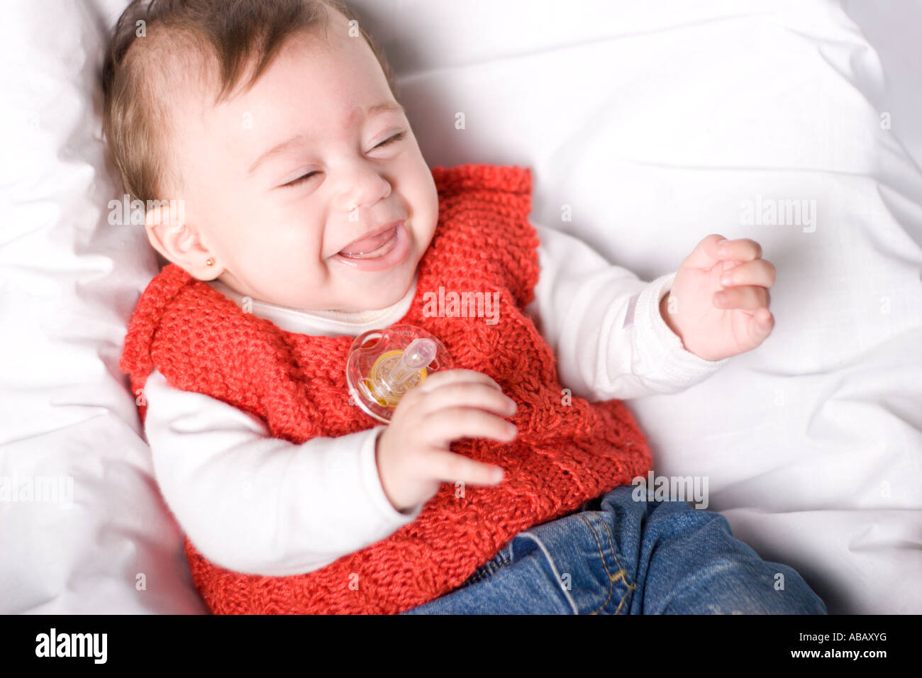 Little baby girl laid down over a white blanket and smiling Stock Photo ...