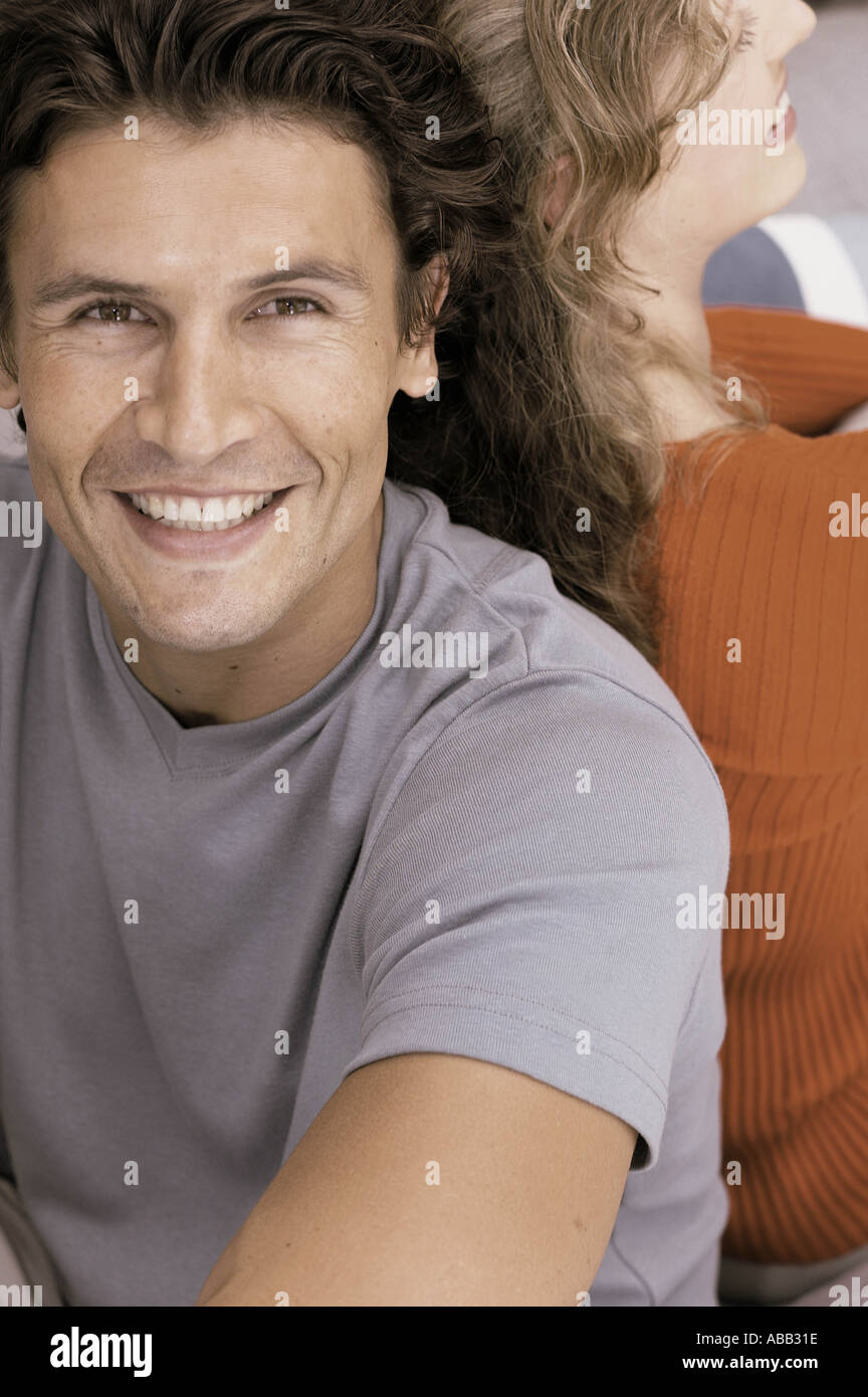 Smiling couple back to back Stock Photo - Alamy