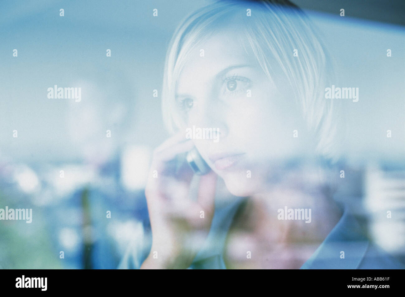 Woman using cellphone behind glass pane Stock Photo - Alamy