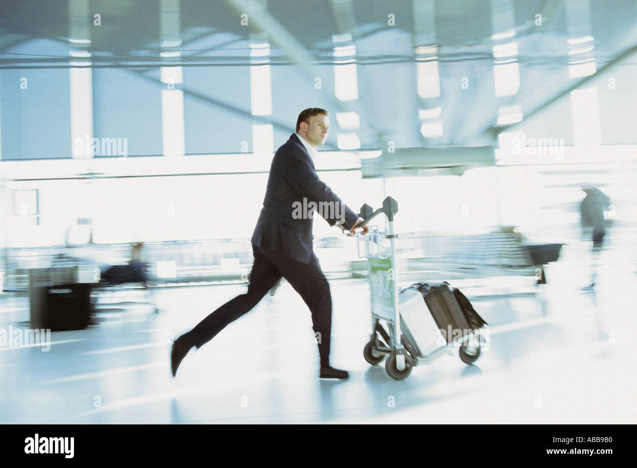 Businessman rushing in airport terminal Stock Photo - Alamy