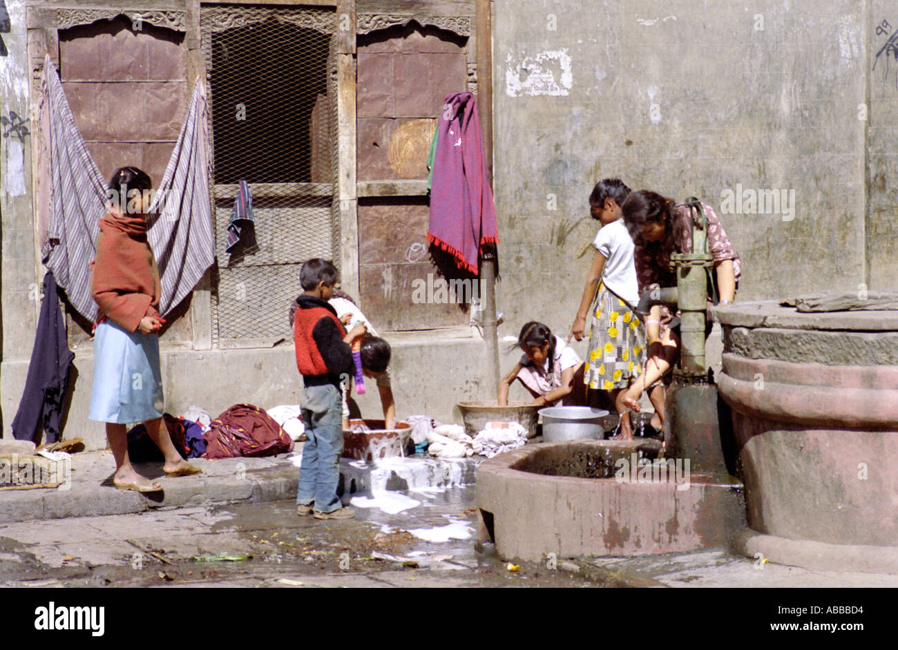 Women and children washing clothes at a street tap Kathmandu Nepal ...