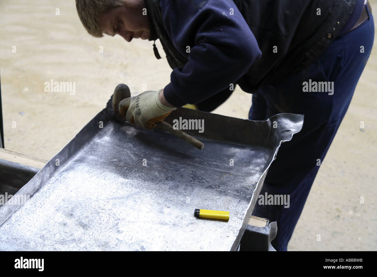 Image of man bossing and dressing lead sheet into the bay of a practice ...