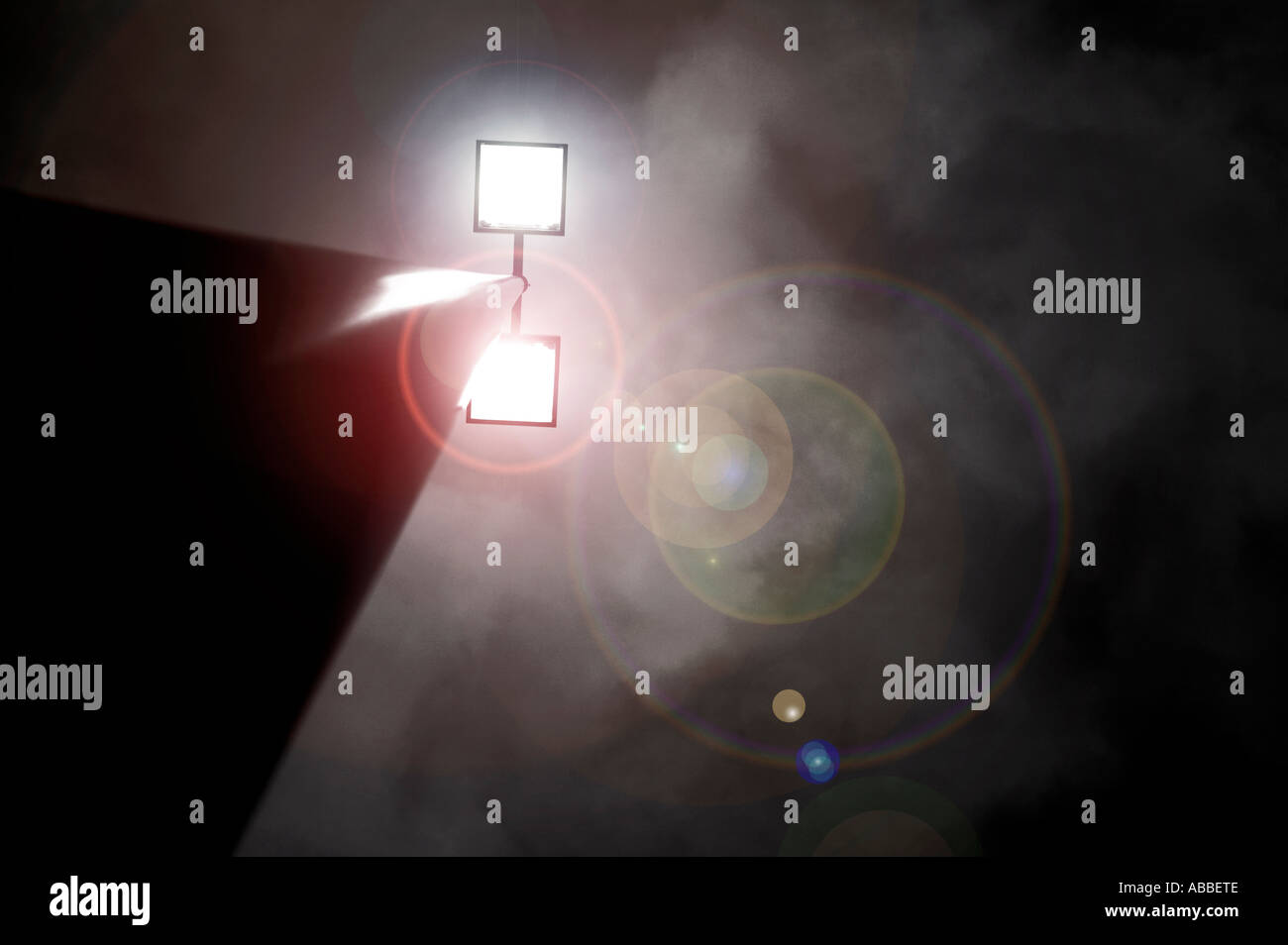 Upward view of two lights on pole and cloudy sky at night, side view ...