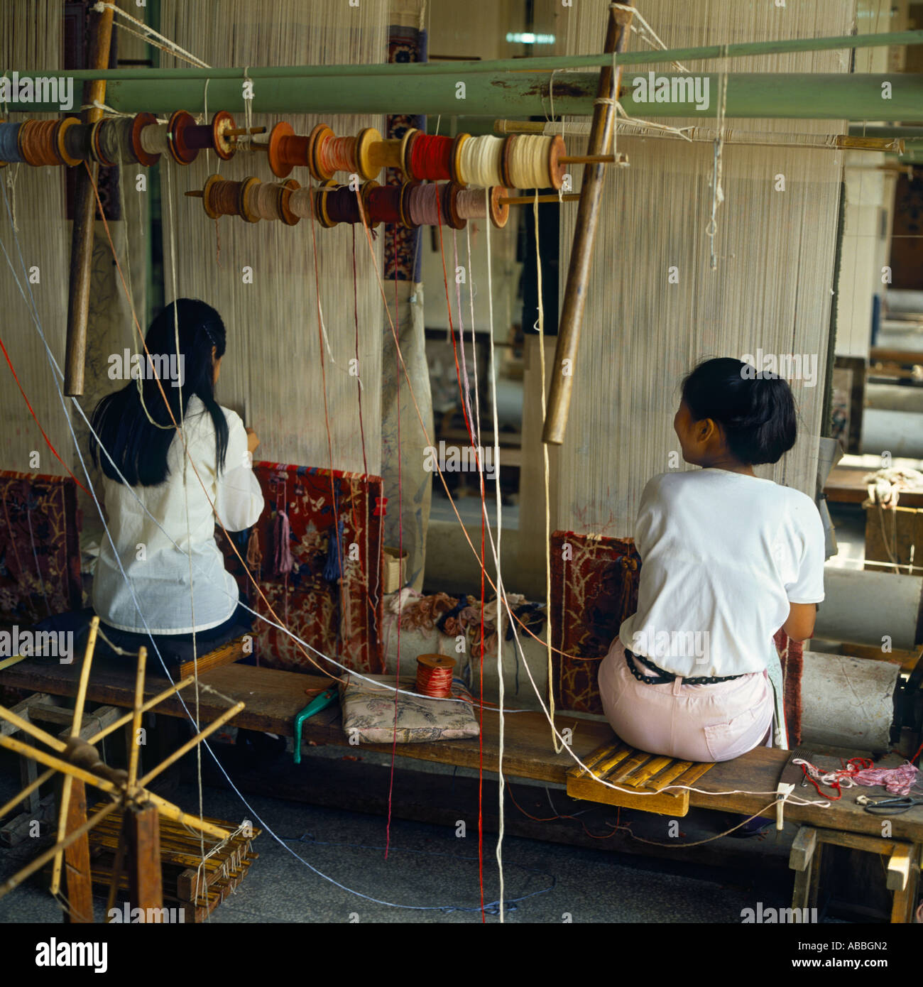 Silk Carpet Factory with two women working skillfully at looms with ...