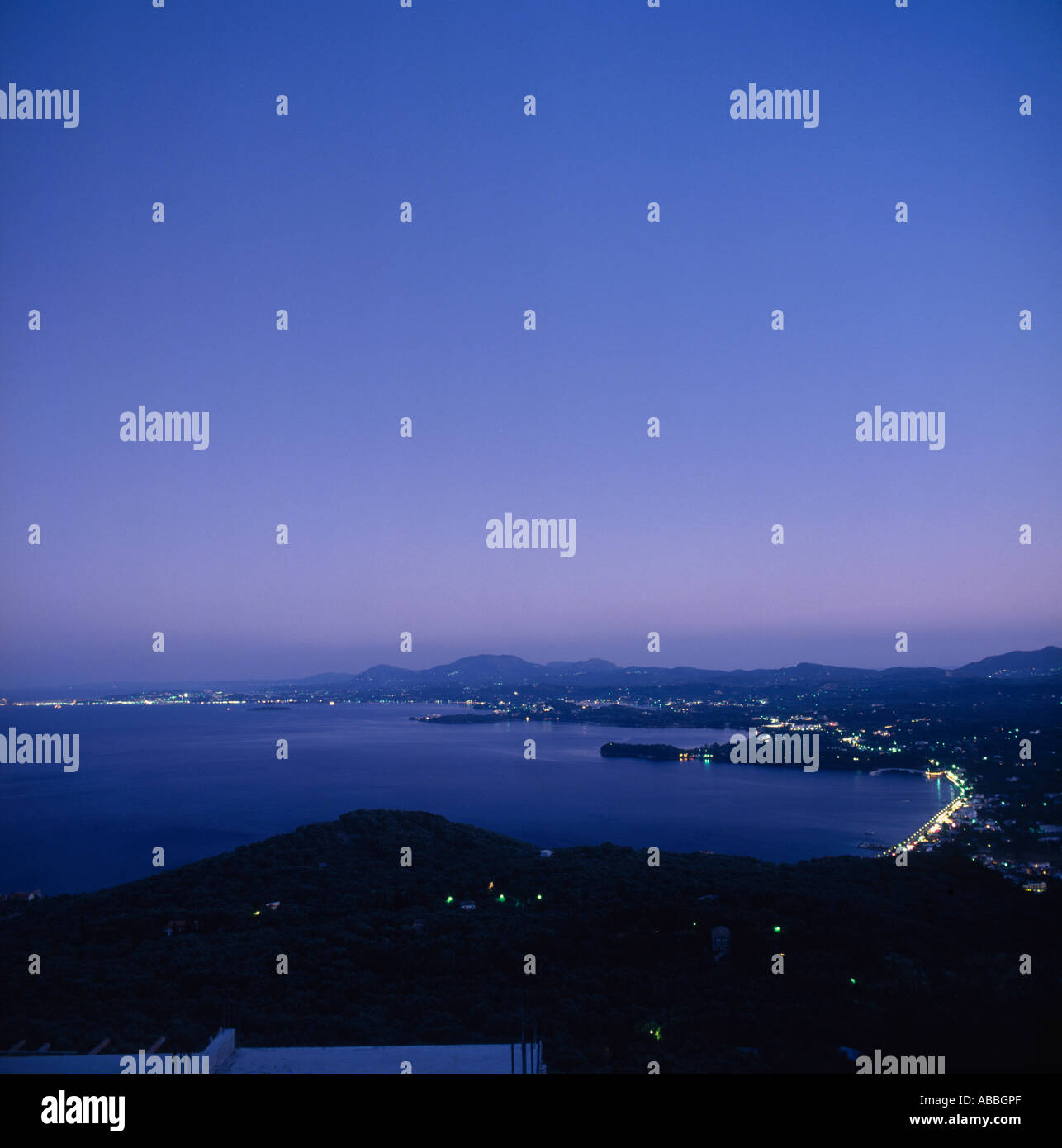 View over the bay at night with lights along the coastal road and on ...