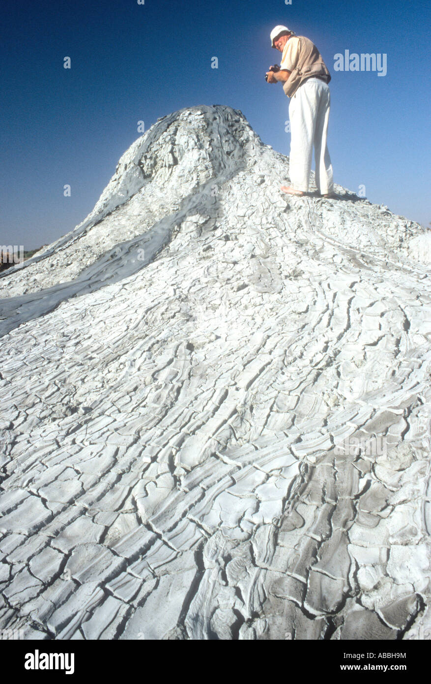 tourist inspecting one of the ACTIVE MUD VOLCANOES AT MINBU IN MYANMAR ...