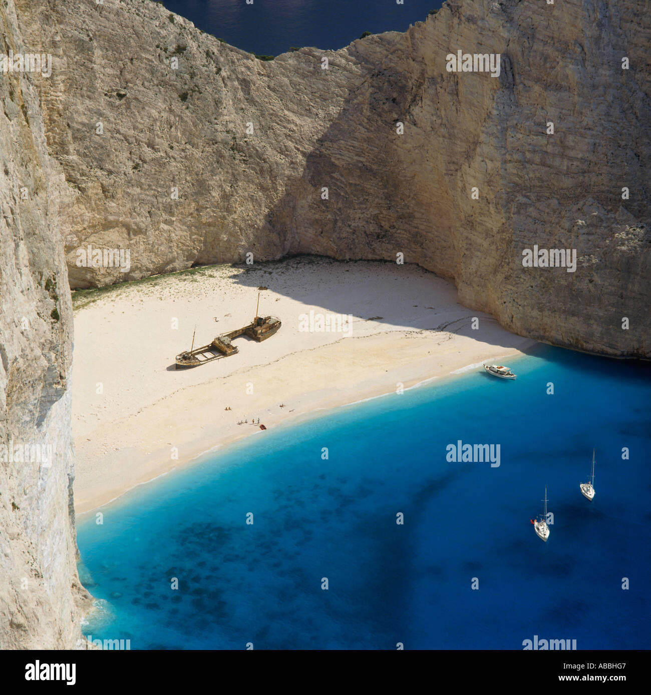 Classic white sand beach with high cliffs boats and deep blue sea at ...