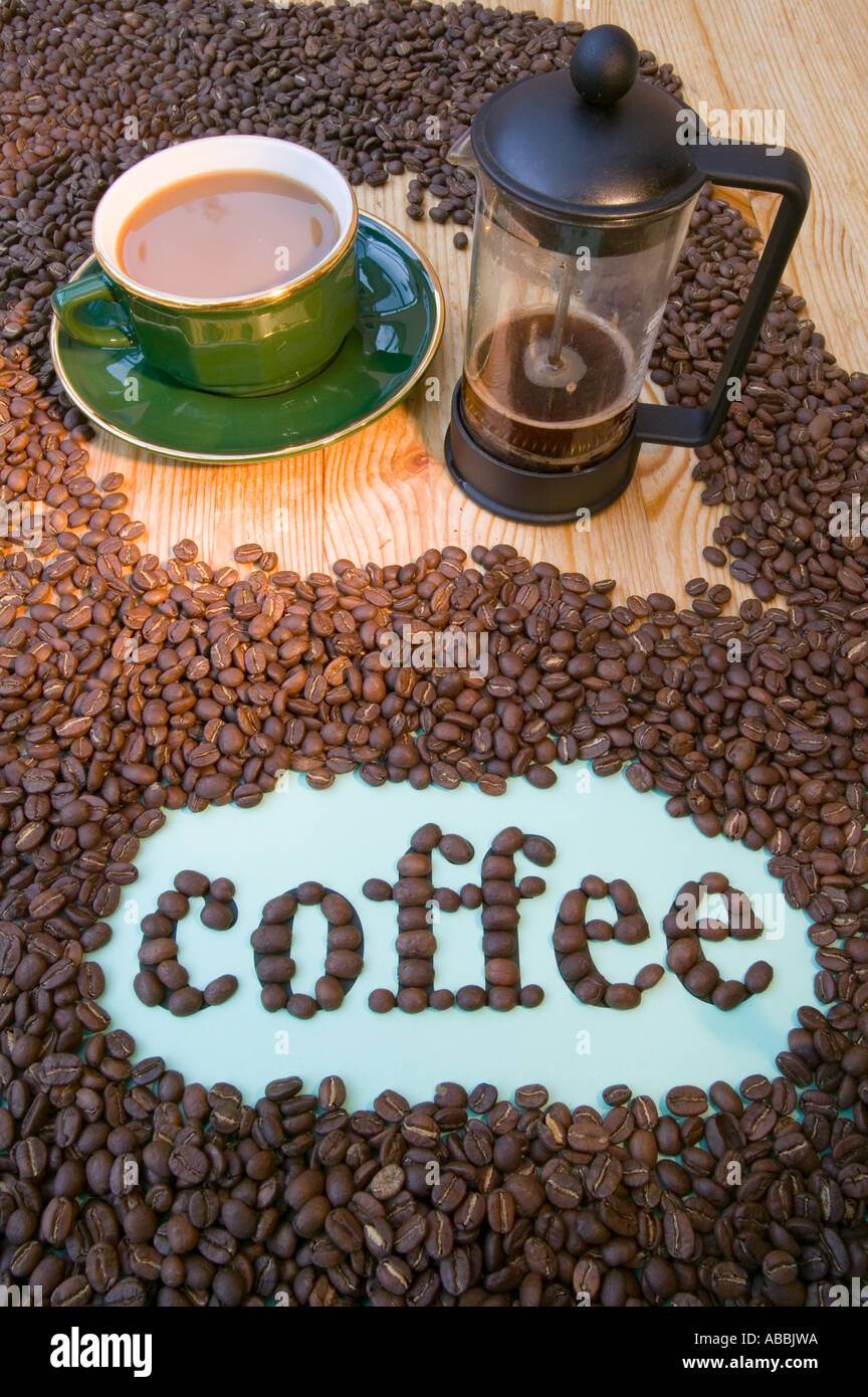 a caffetiere of coffee with cup and coffee beans spelling out the word ...