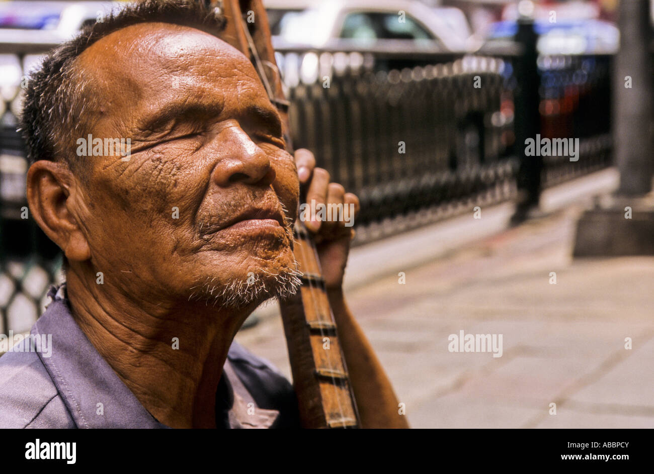 Blind man playing an instrument in Bangkok, Thailand Stock Photo - Alamy