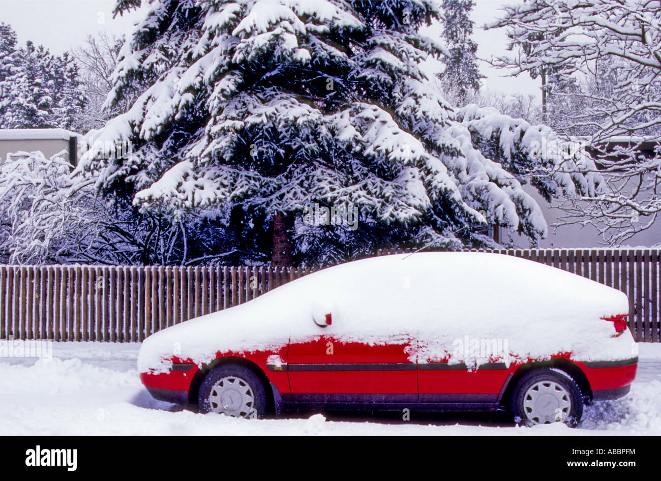 Red car covered in snow Stock Photo - Alamy