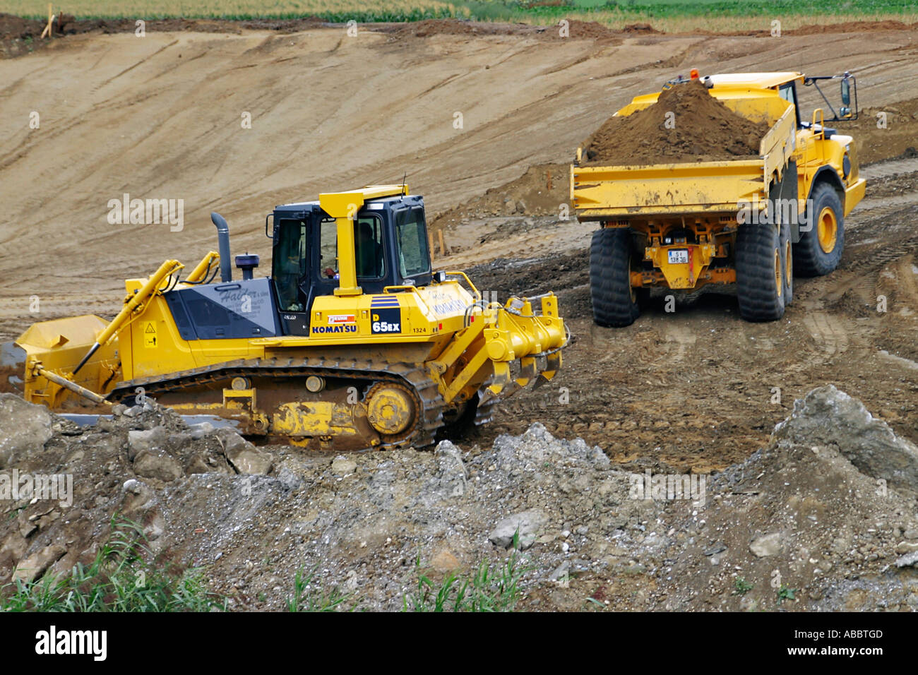 Crawler-type vehicle and truck on a building site Stock Photo - Alamy