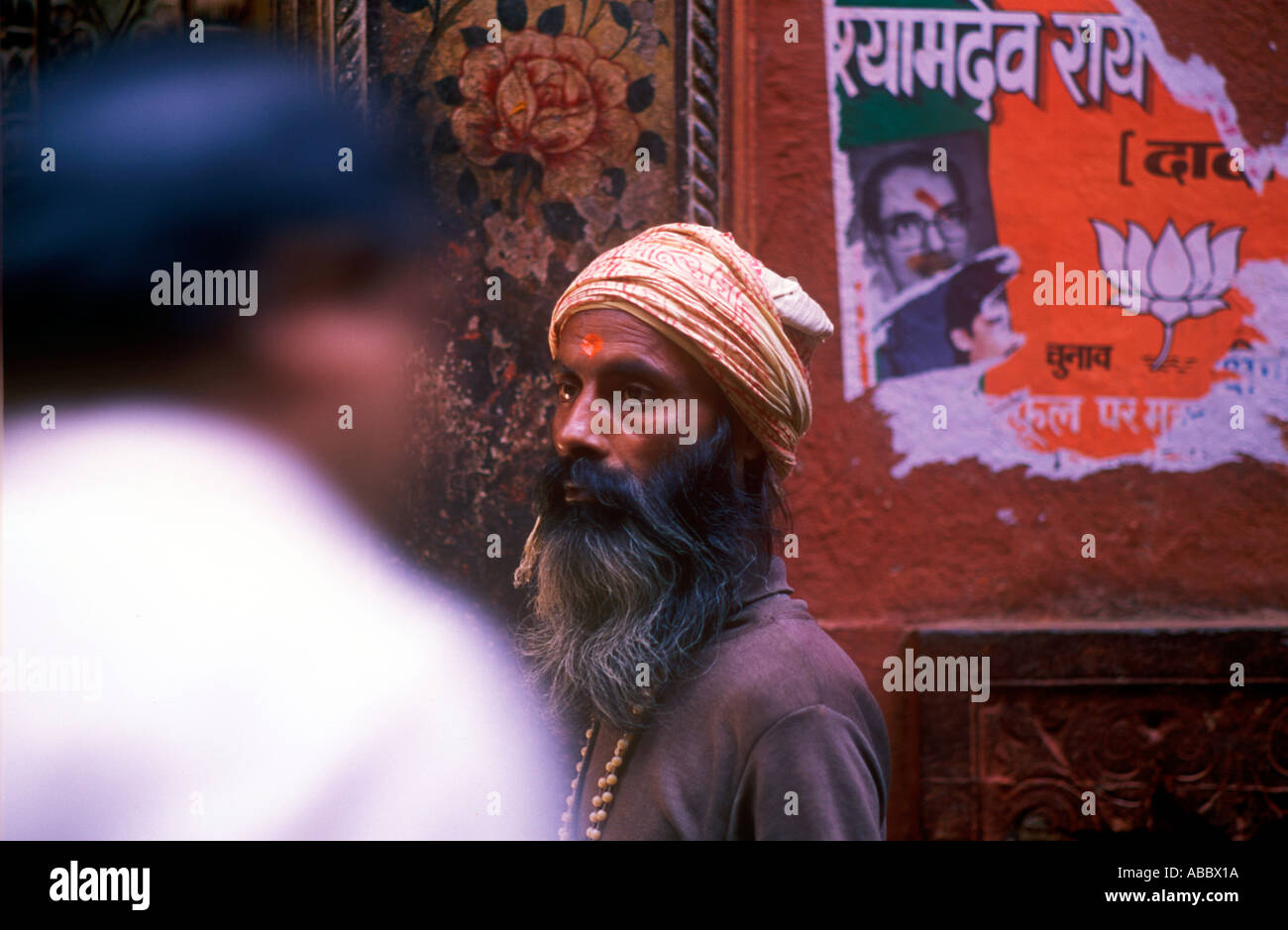 CMP70360 Indian Sadhu wearing strange cap head gear near the holy river ...