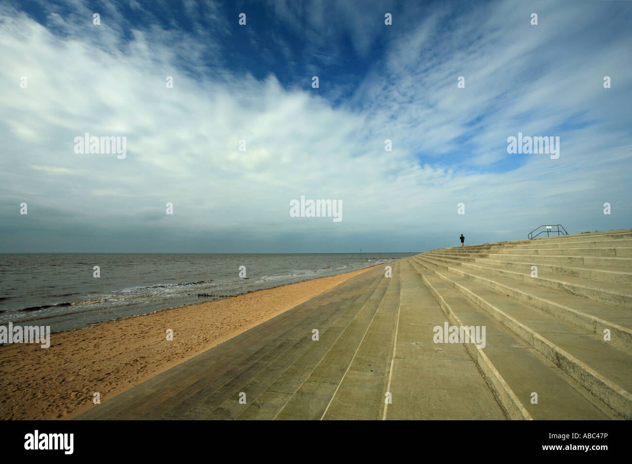 A lone man running into the distance beneath a dramatic sky along the ...