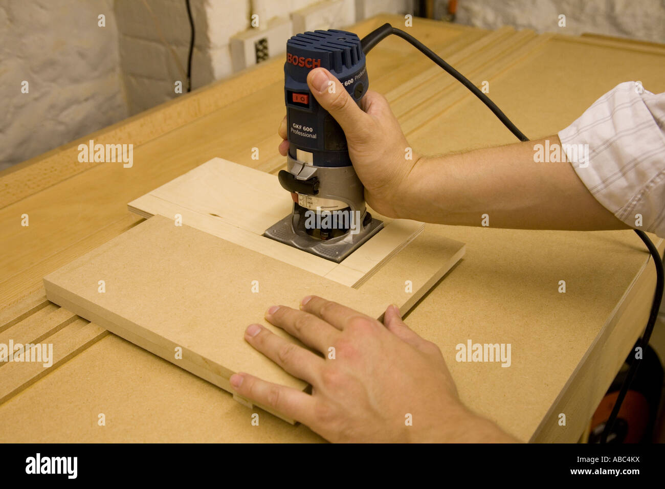 Craftsman uses a router with a dedicated jig to cut a housing joint in ...