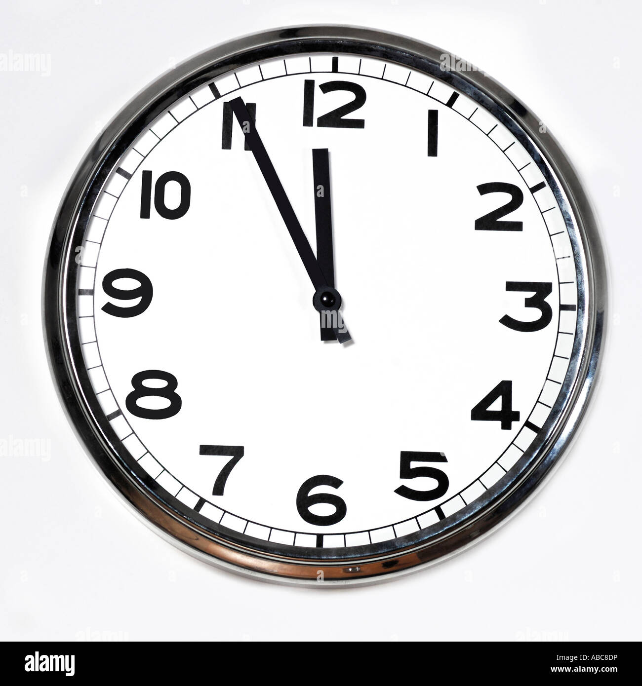 black and white clock at five to twelve isolated on a white background ...