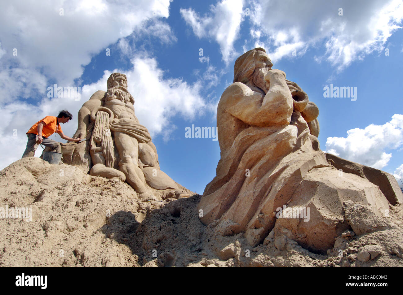 A sand sculptor creates a reclining figure as part of a display based ...