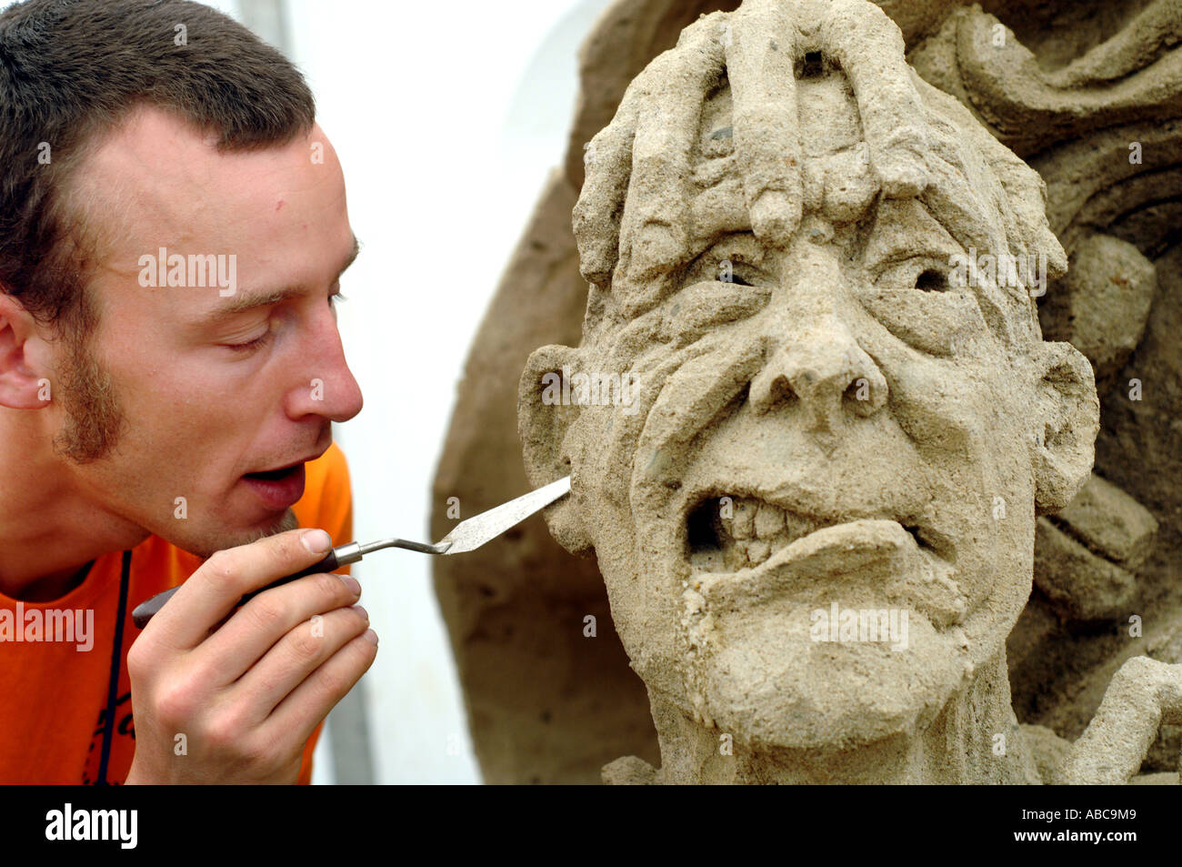 Now this won't hurt a bit. A sand sculptor creates a grotesque figure ...