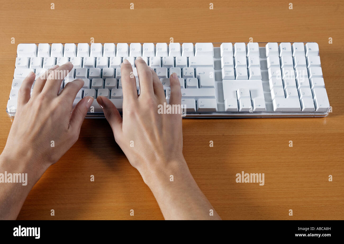 hand typing on a wireless white keyboard computer posed on atable Stock ...