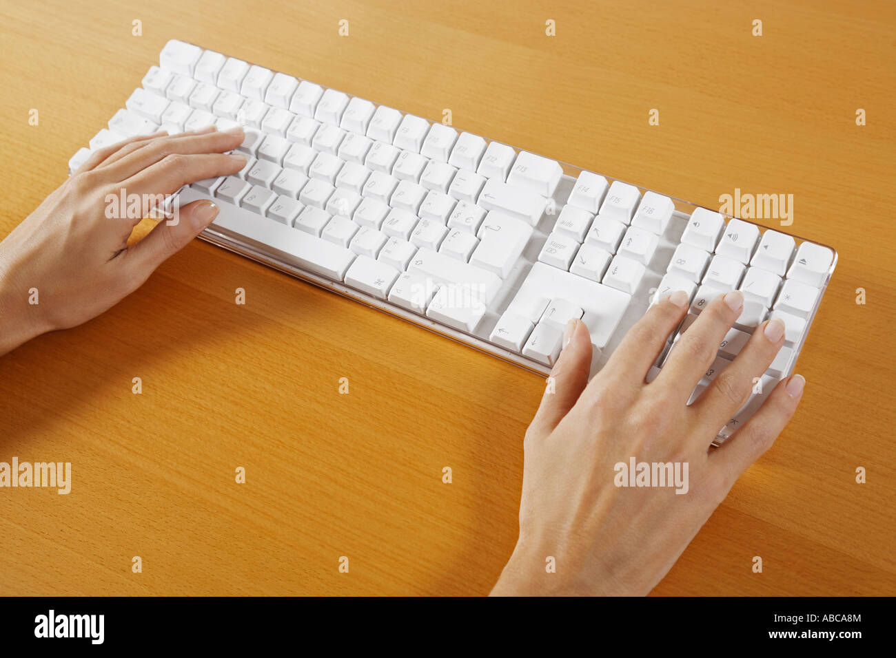 hand typing on a wireless white keyboard computer posed on atable Stock ...