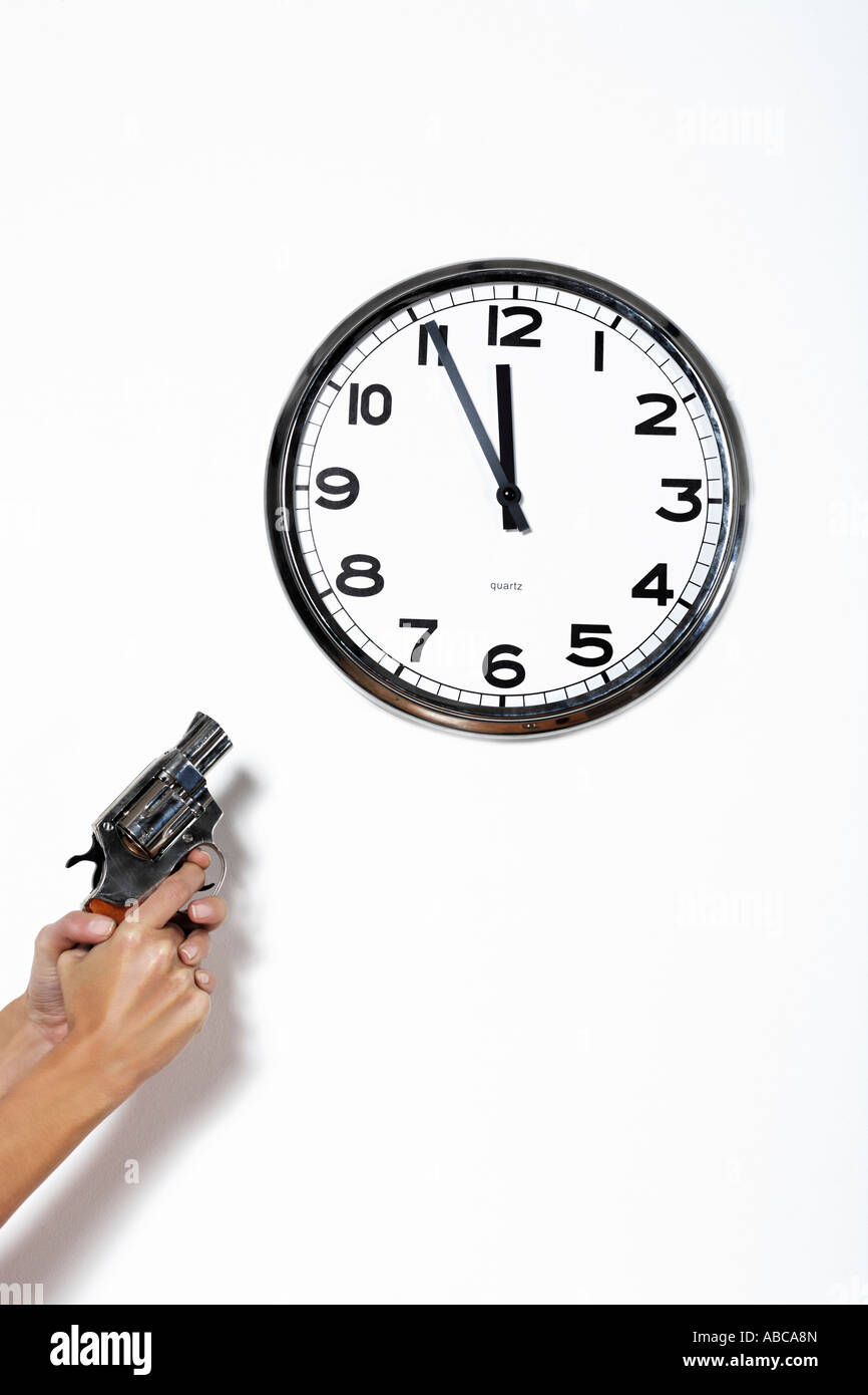 gun pointing black and white clock at five to twelve isolated on a ...