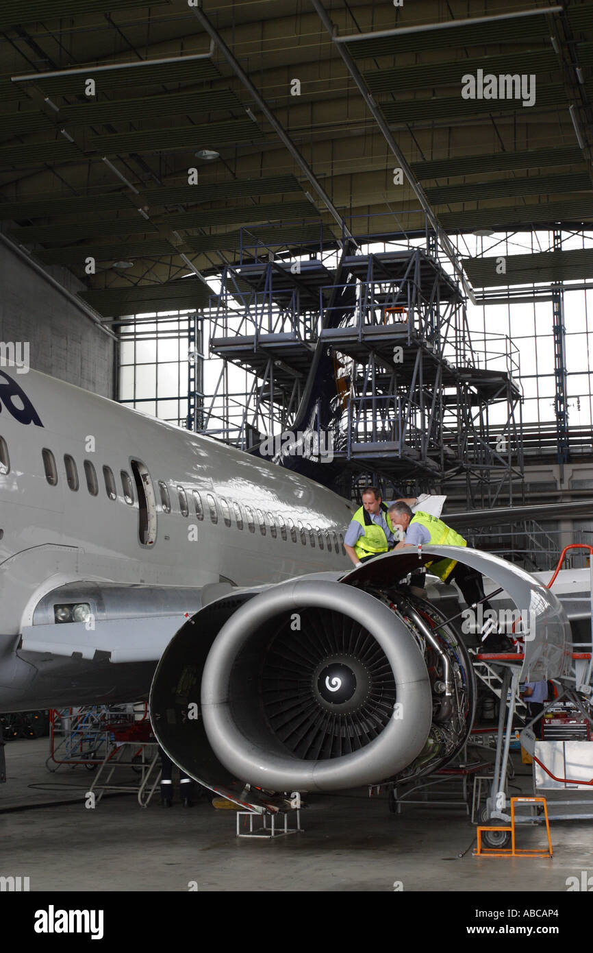 Airliner maintenance engineers work on a Boeing 737 aircraft CFM-56 jet ...