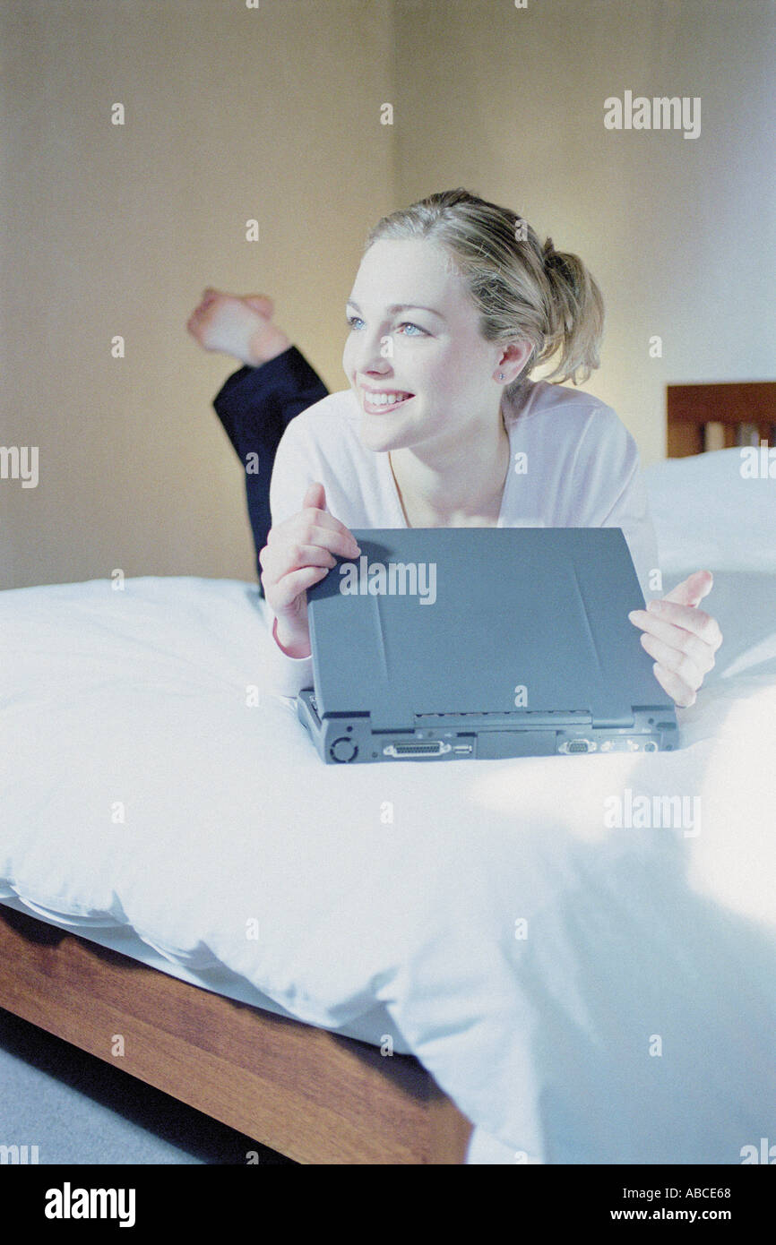 Woman in bedroom with laptop Stock Photo - Alamy