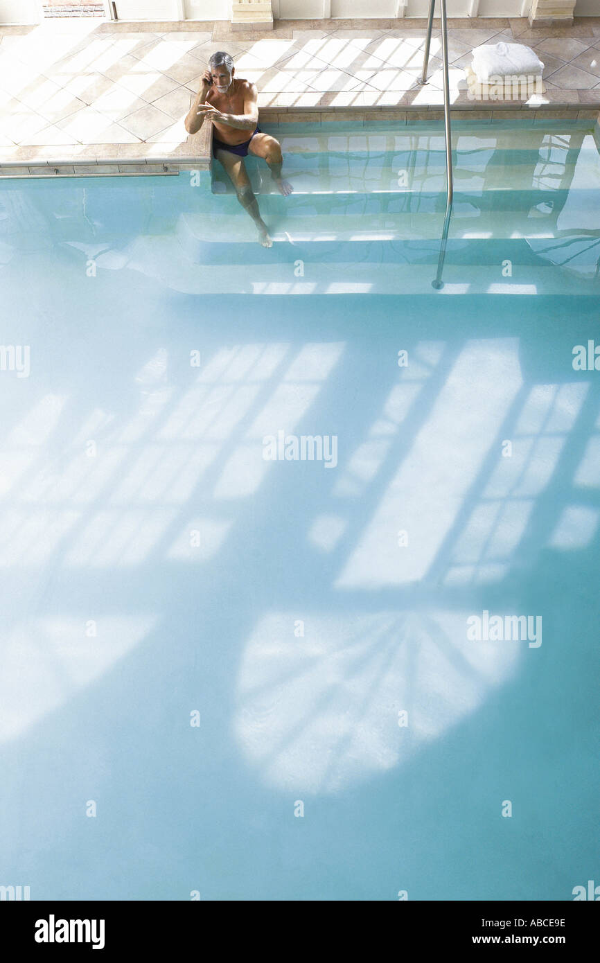 Man on the edge of swimming pool Stock Photo - Alamy