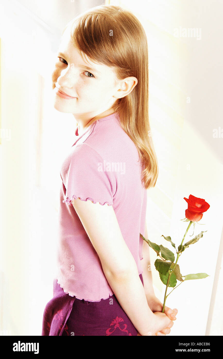 Smiling girl holding red rose Stock Photo - Alamy