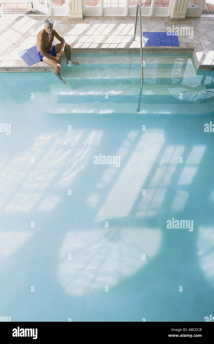 Man on the edge of swimming pool Stock Photo - Alamy