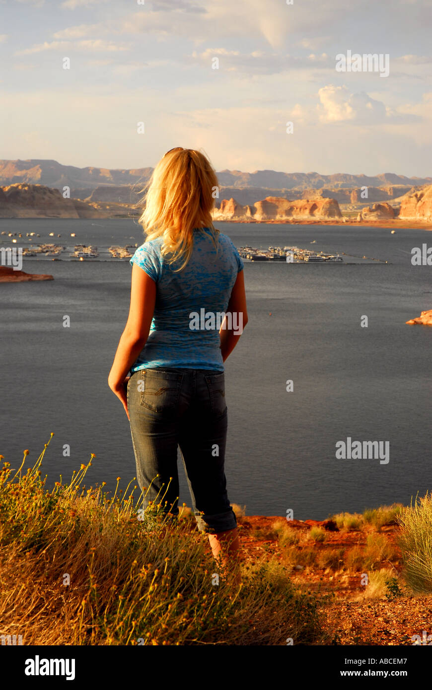 Arizona Lake Powell woman standing alone on cliff red desert mesa in ...