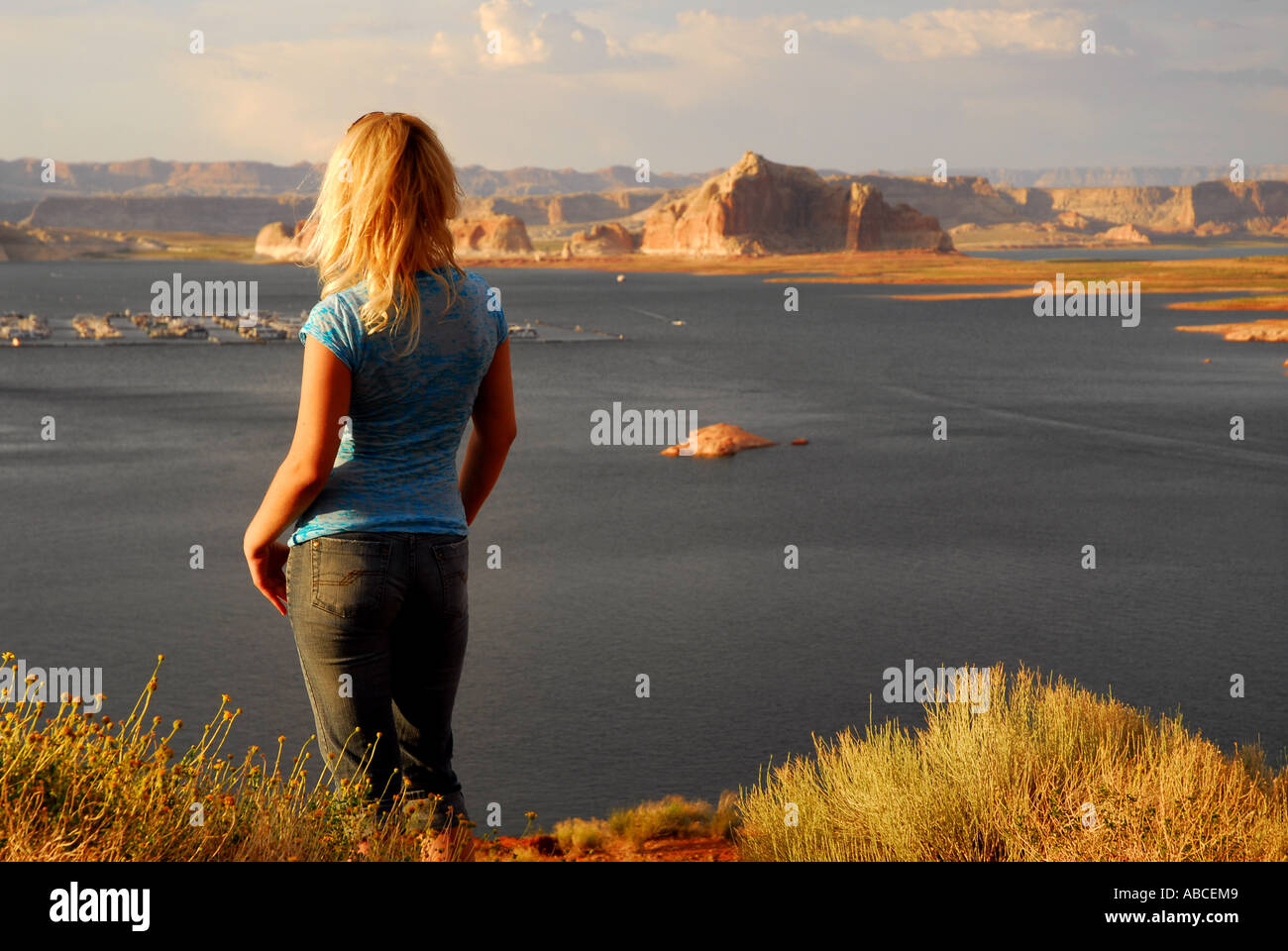 Arizona Lake Powell woman standing alone on cliff red desert mesa in ...