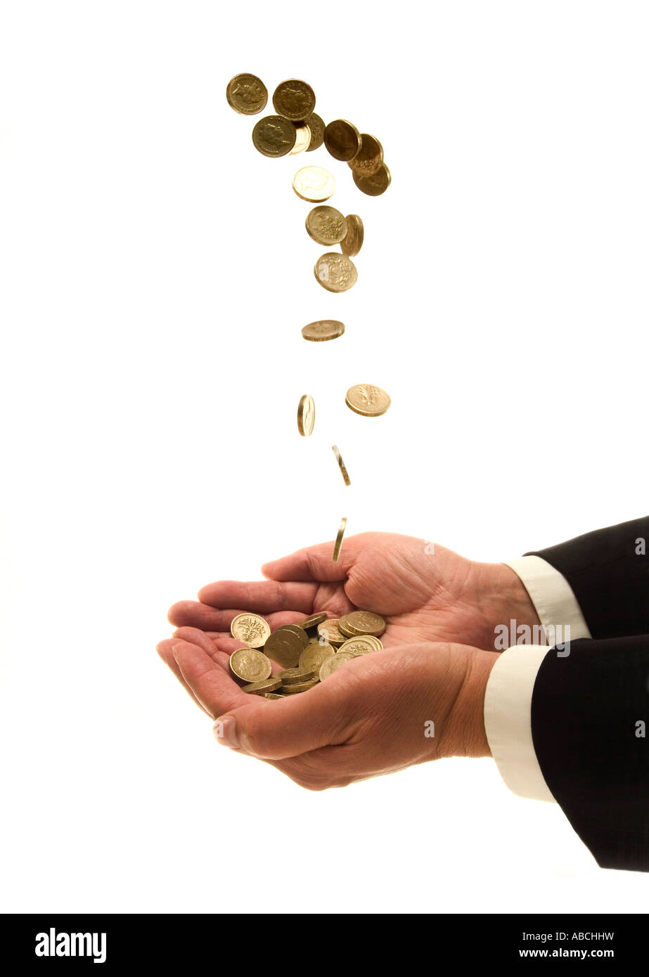 Pound coins falling into mans hands Stock Photo - Alamy
