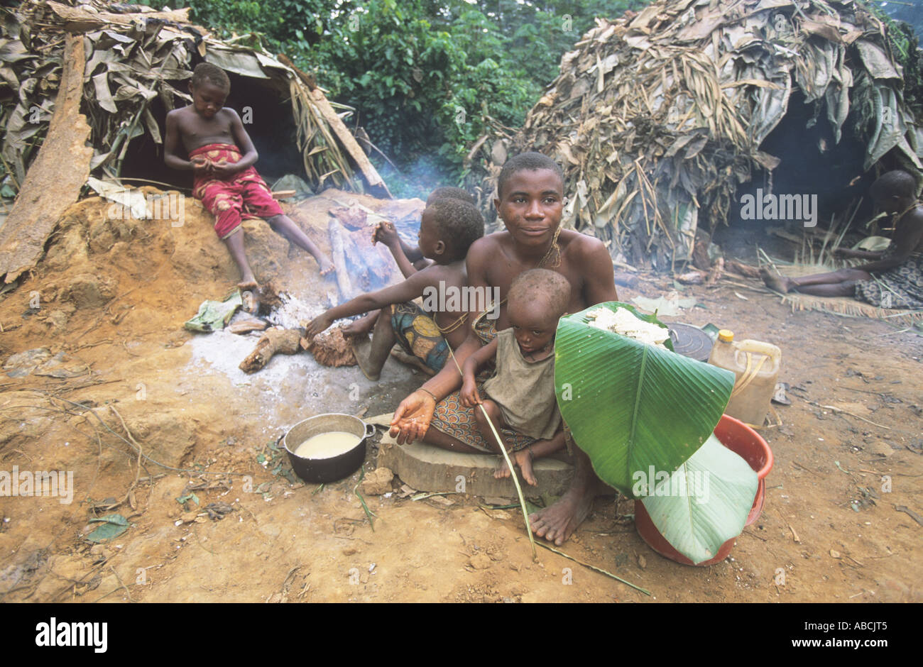 A Baka pygmy family by their temporary leaf houses in the rainforest of ...