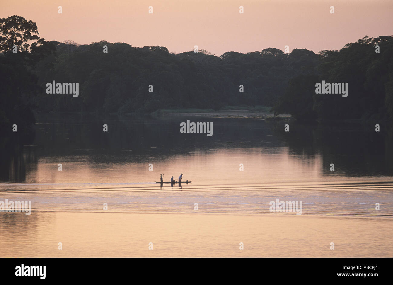 Sunset over the rainforest and Sangha River with canoe on the frontier ...