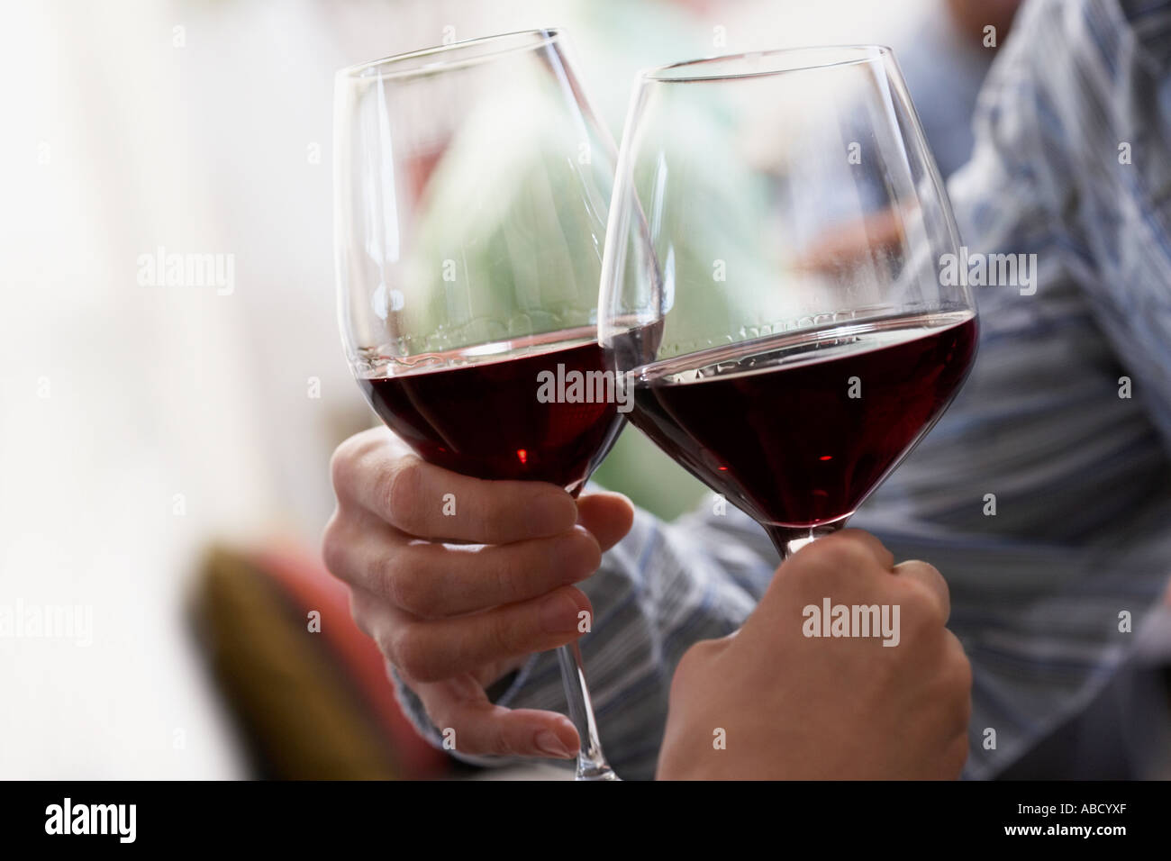 Couple toasting with red wine Stock Photo - Alamy