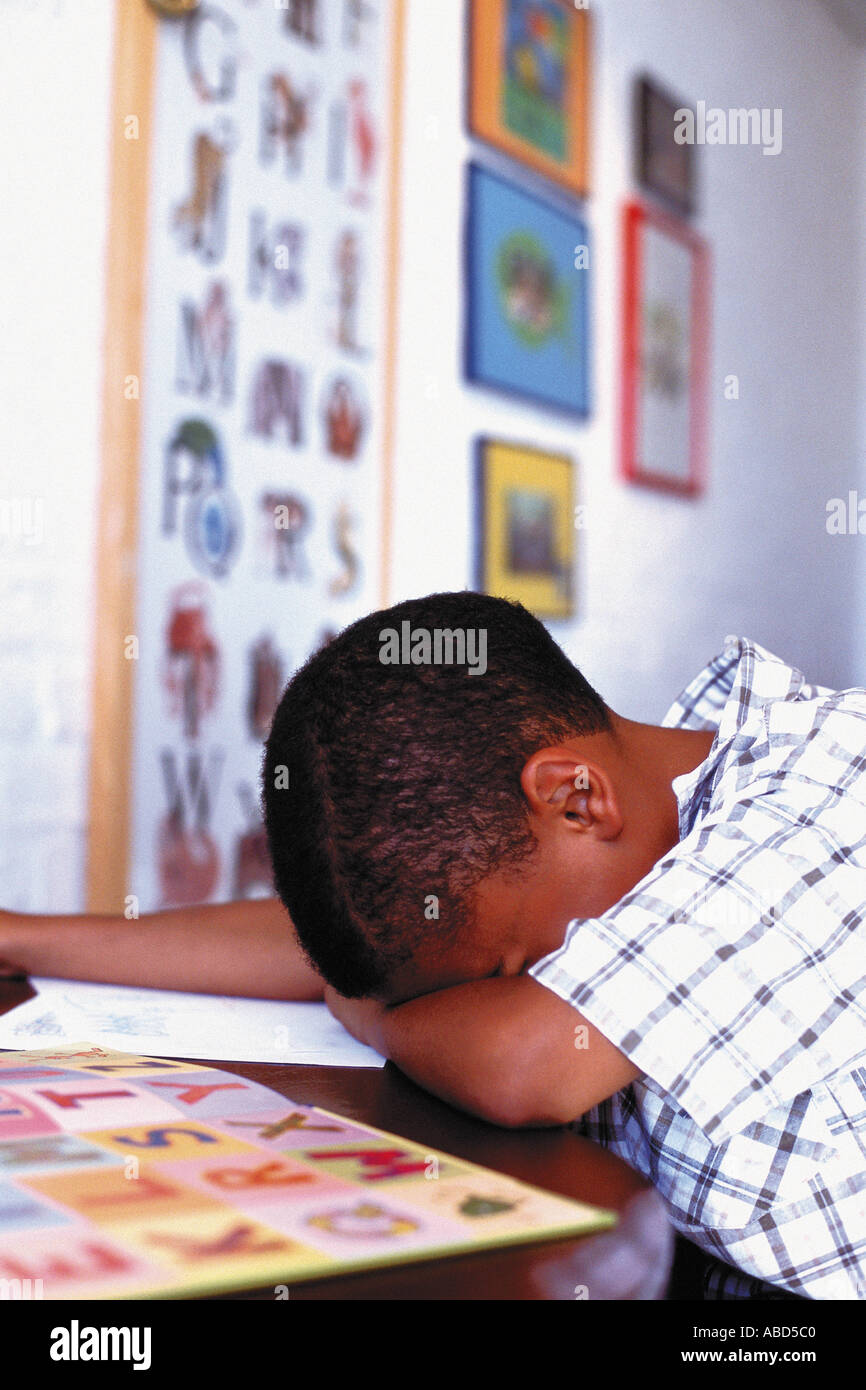 Boy sleeping over homework Stock Photo - Alamy