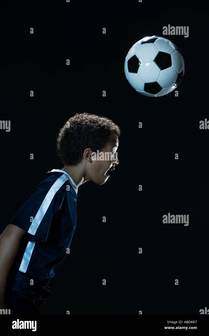 Boy heading a football Stock Photo - Alamy