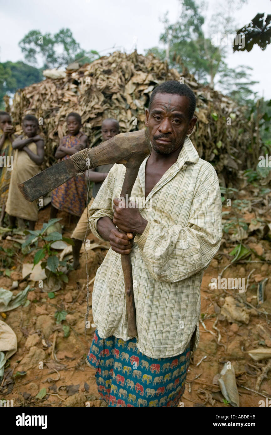 Pygmy man with agricultural tool about to visit his garden in the ...