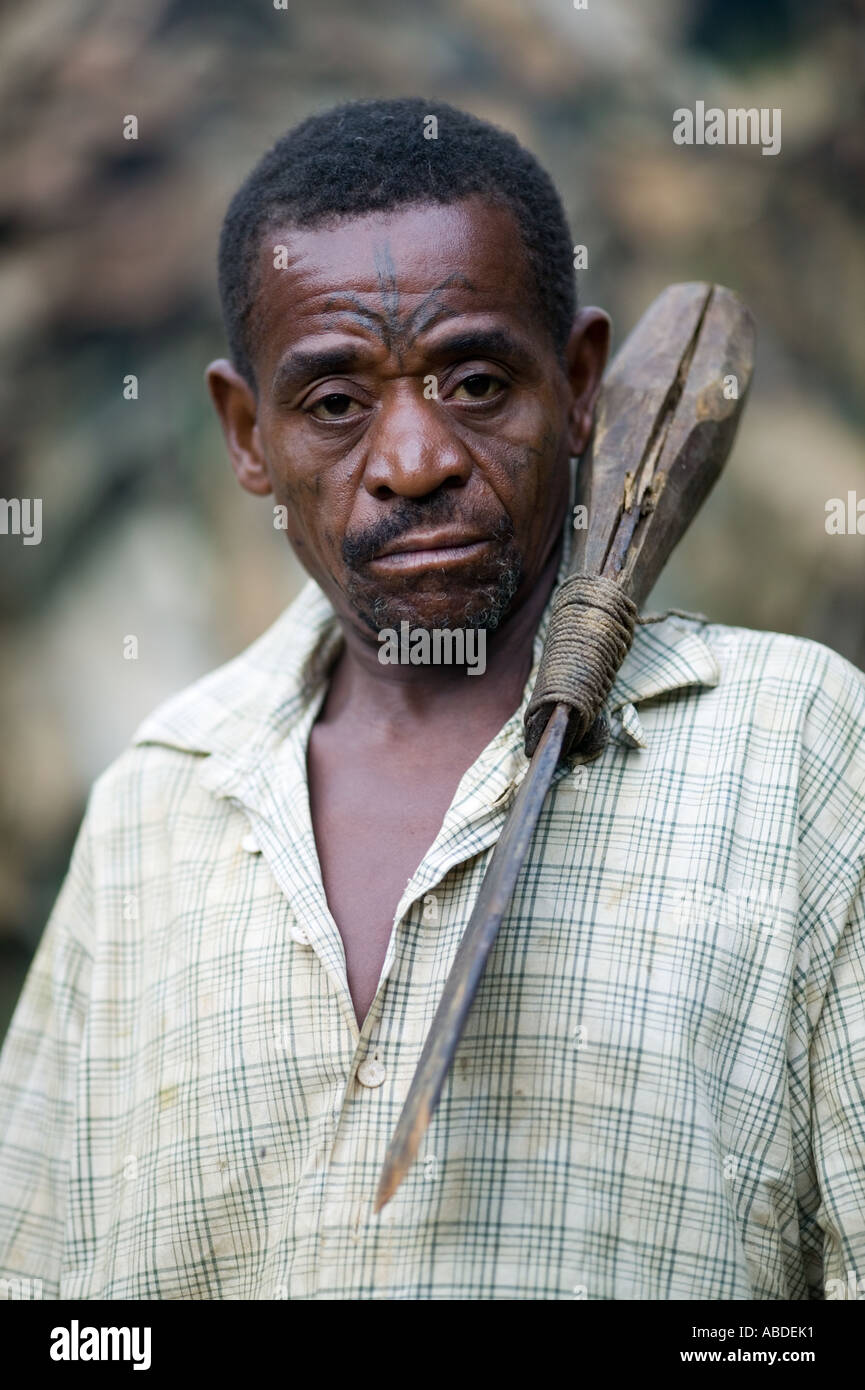 Pygmy man with agricultural tool about to visit his garden in the ...