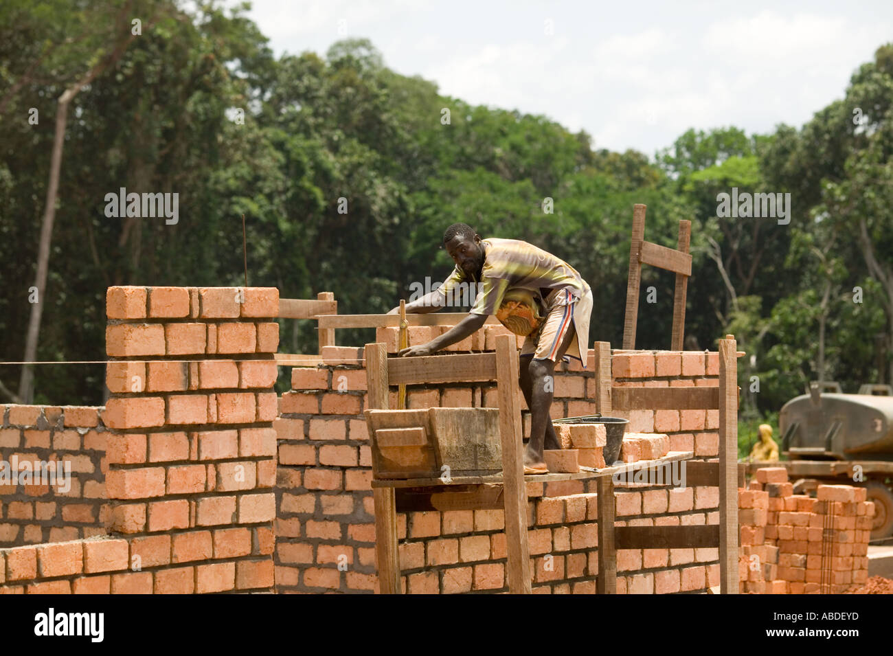 A man making new brick houses in the rainforest of the Republic of ...