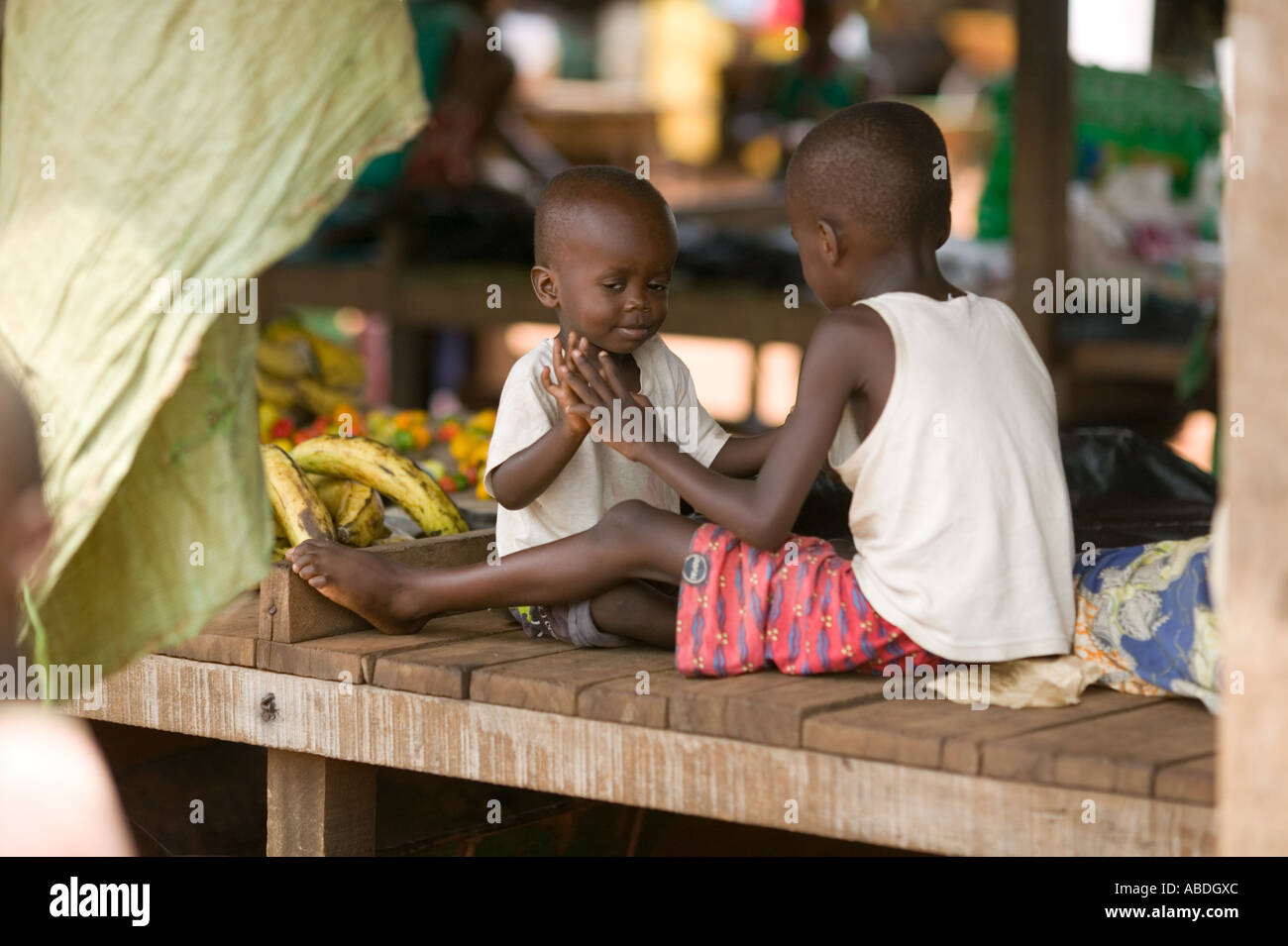 Children playing while the mother sells goods at the market in the ...